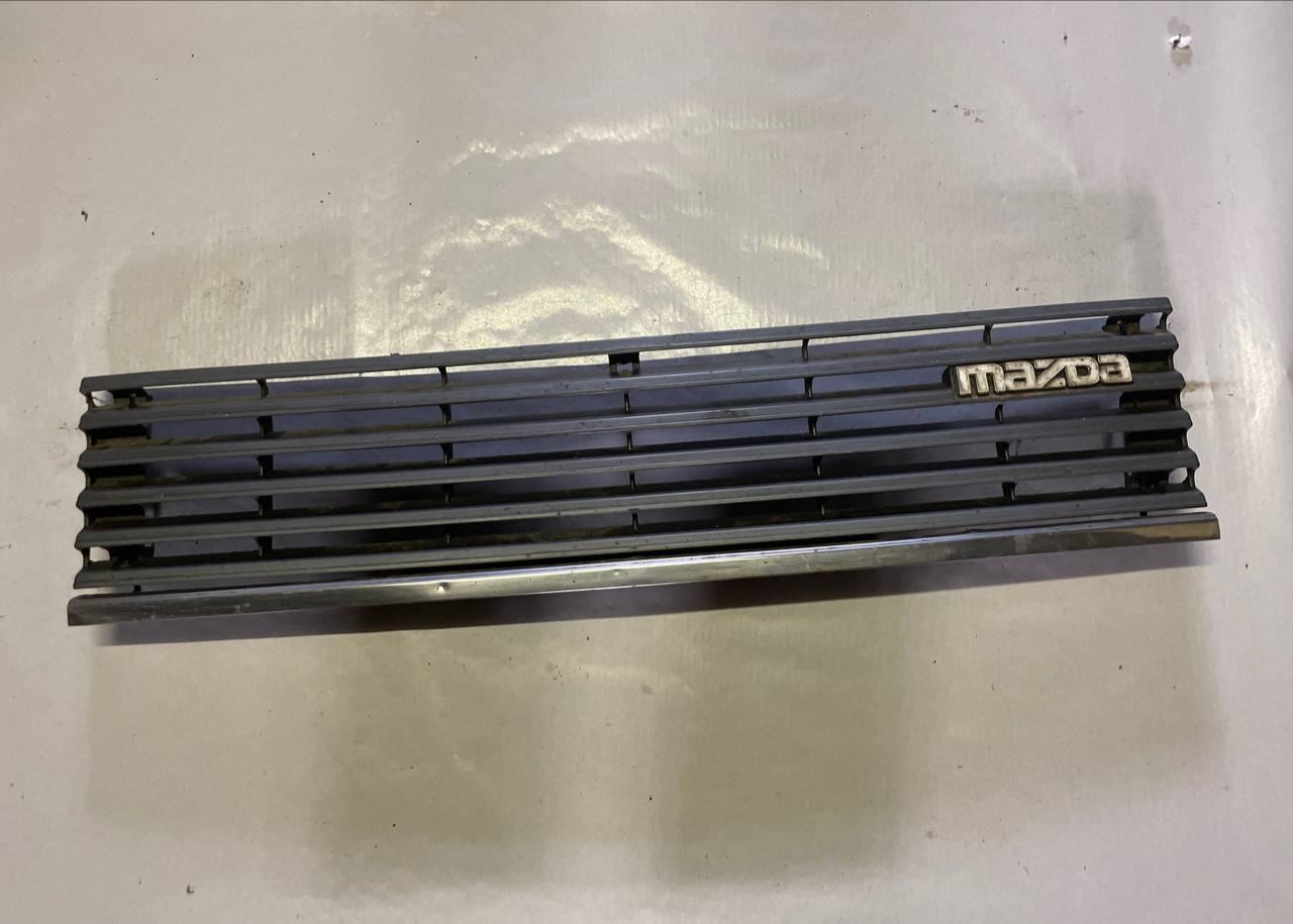 323 maska MAZDA grill spredaj+znak mrežica emblem OEM original