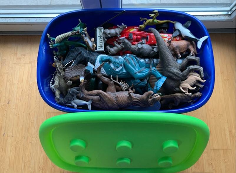 Škatla plastičnih figur in različnih igrač